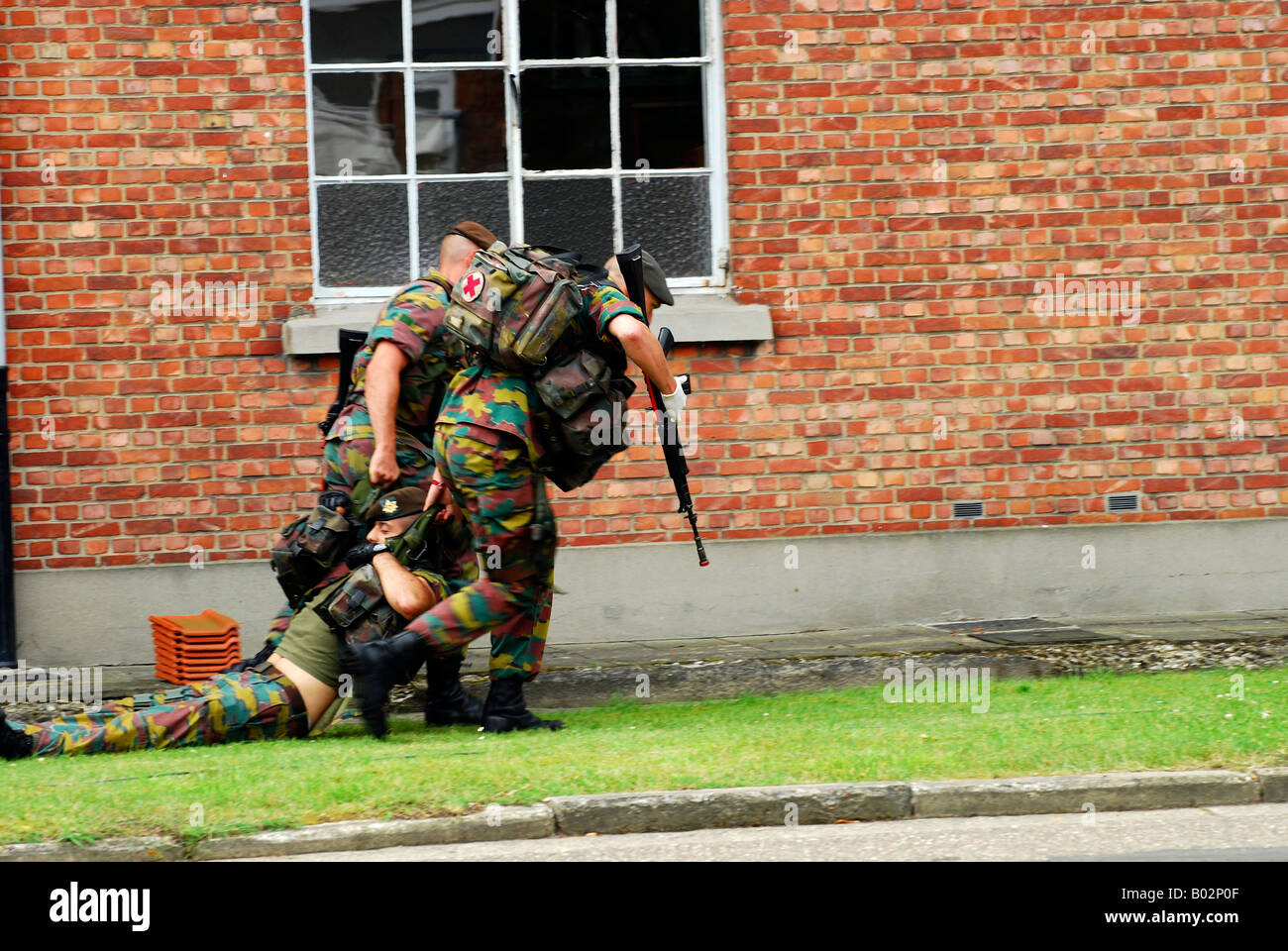 Soldiers of the Belgian Army helping and transporting a wounded mate ...