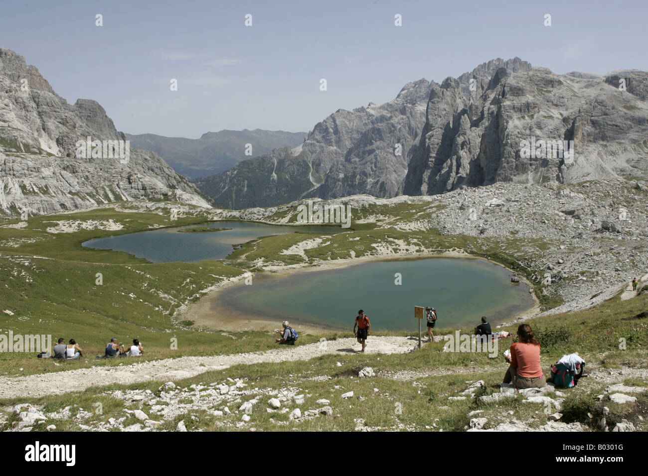 Hikers resting around the Boedensee lakes on the Tre Cime plateau in ...