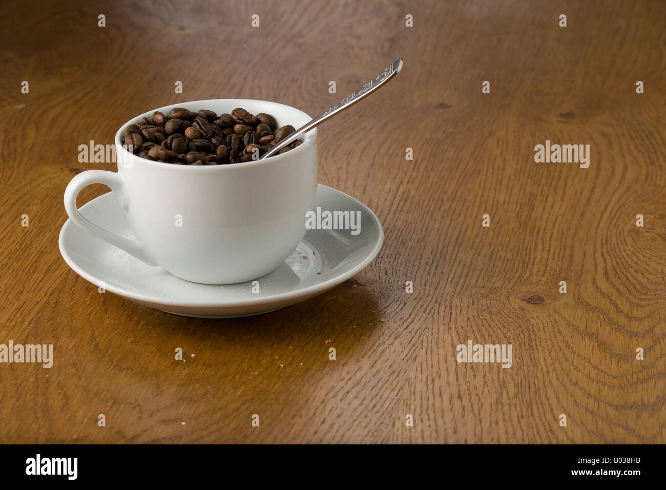 Coffe cup filled with beans on wooden table Spoon inside Stock Photo ...