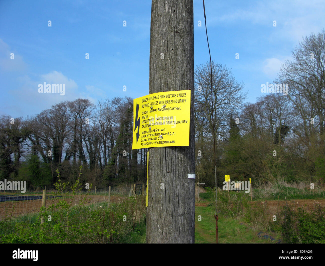 A sign warning of overhead danger is several languages, mostly East ...