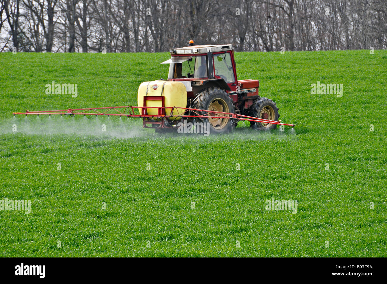 A tractor spraying a treatment in a field Stock Photo - Alamy