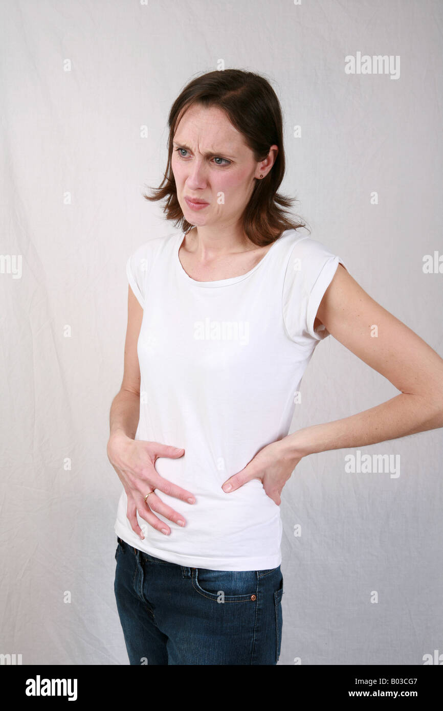 Young woman holds stomach suffering from digestive discomfort female ...