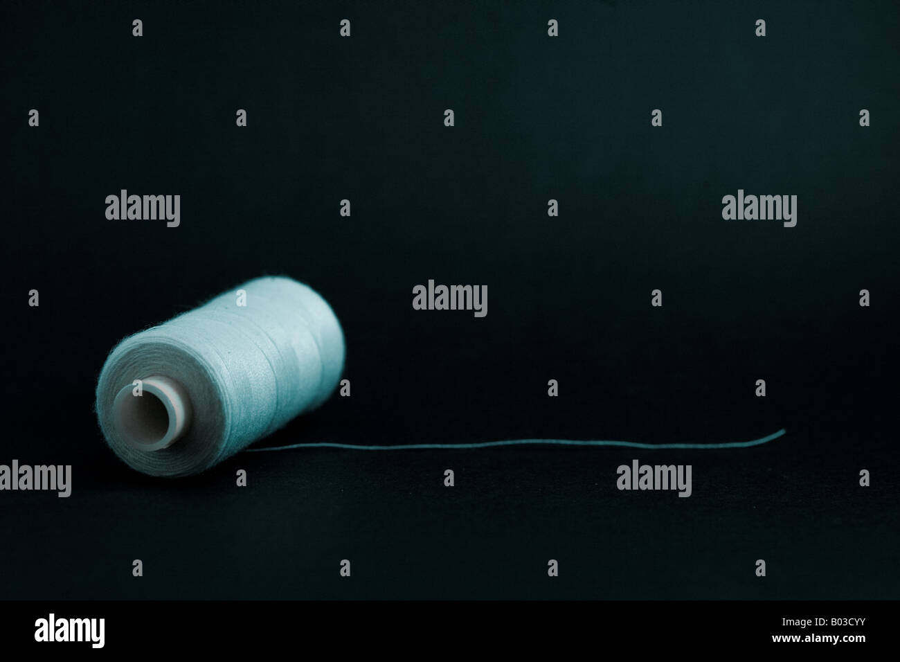 White sew thread on a black background Stock Photo - Alamy