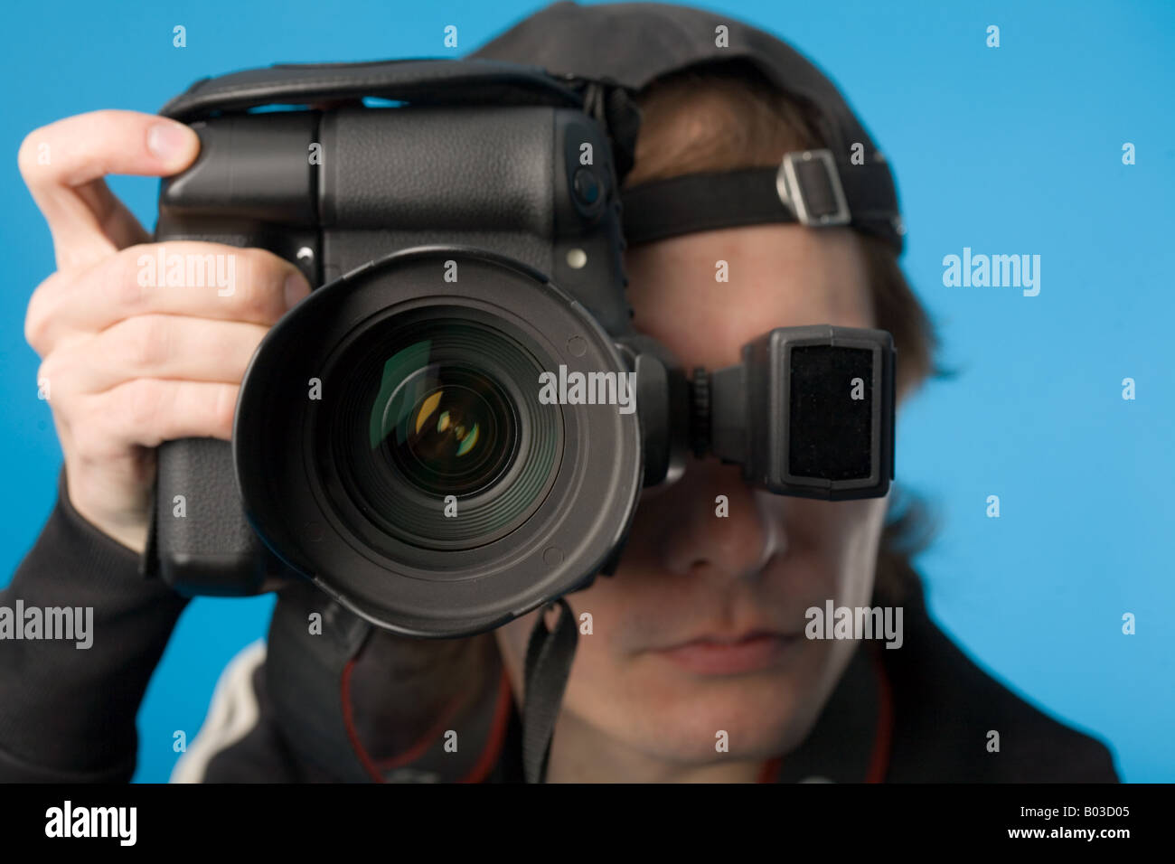 the young photographer with camera on blue background Stock Photo - Alamy