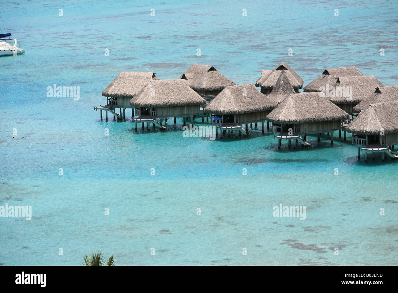 Beach huts along a pontoon within the lagoon around Moorea island in ...