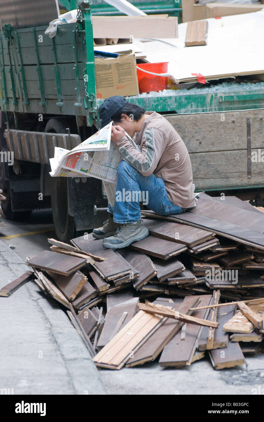 Workman reading paper Stock Photo - Alamy