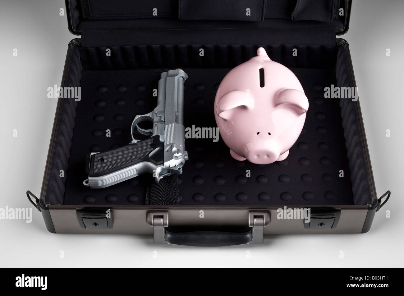 Piggy bank and a gun in a briefcase Stock Photo - Alamy
