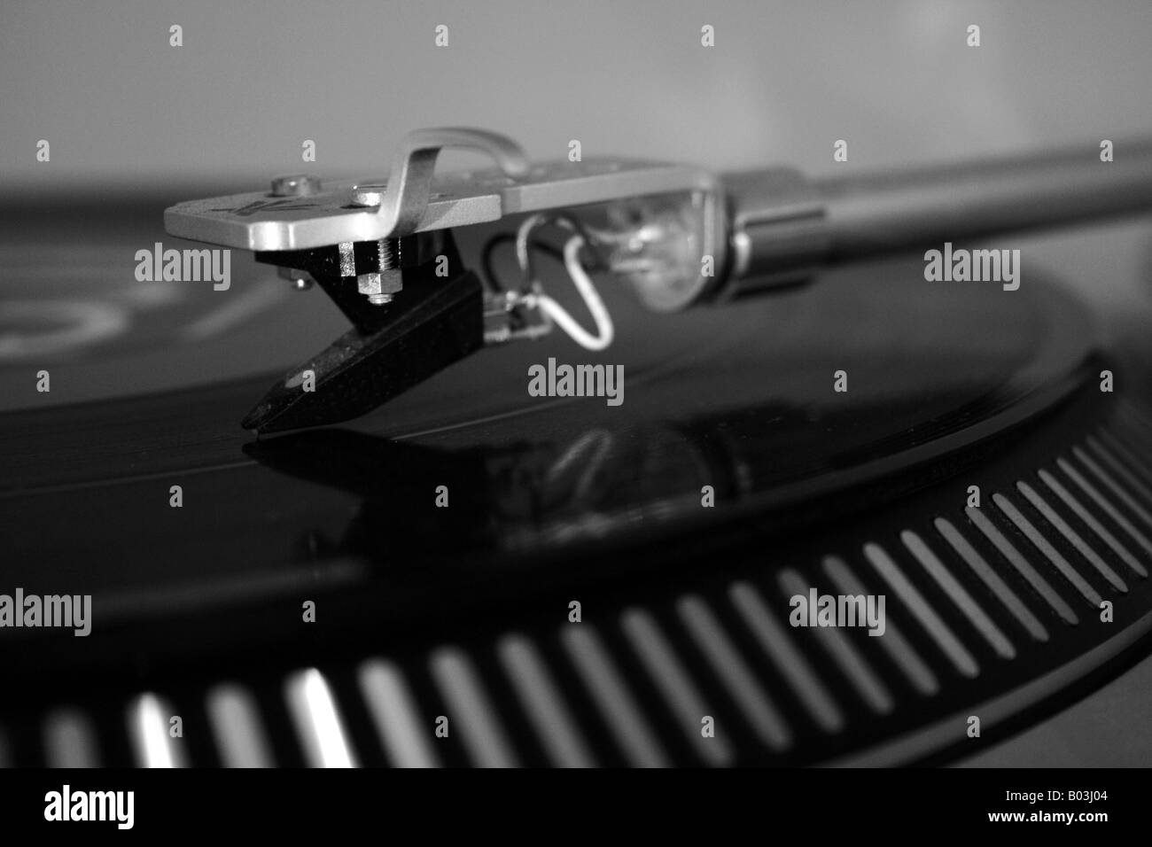 Black and white close-up of a stylus tracking across a vinyl record ...
