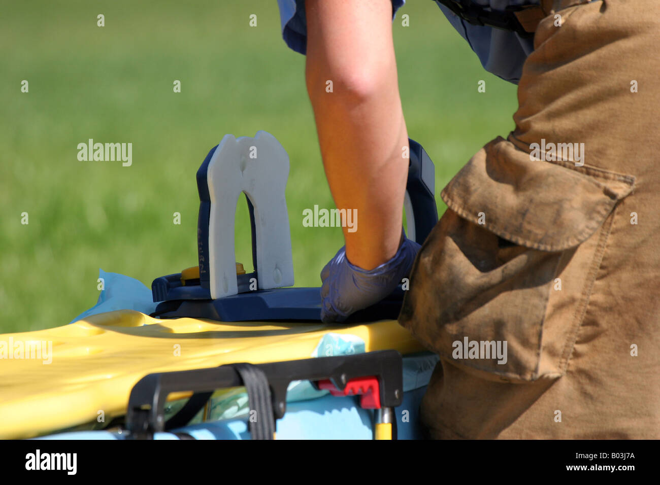 An EMS worker preparing the neck brace on a back board for a victim ...
