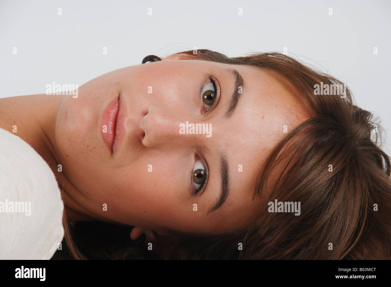 Pretty teenage girl with serious inquiring expression lying down Stock ...