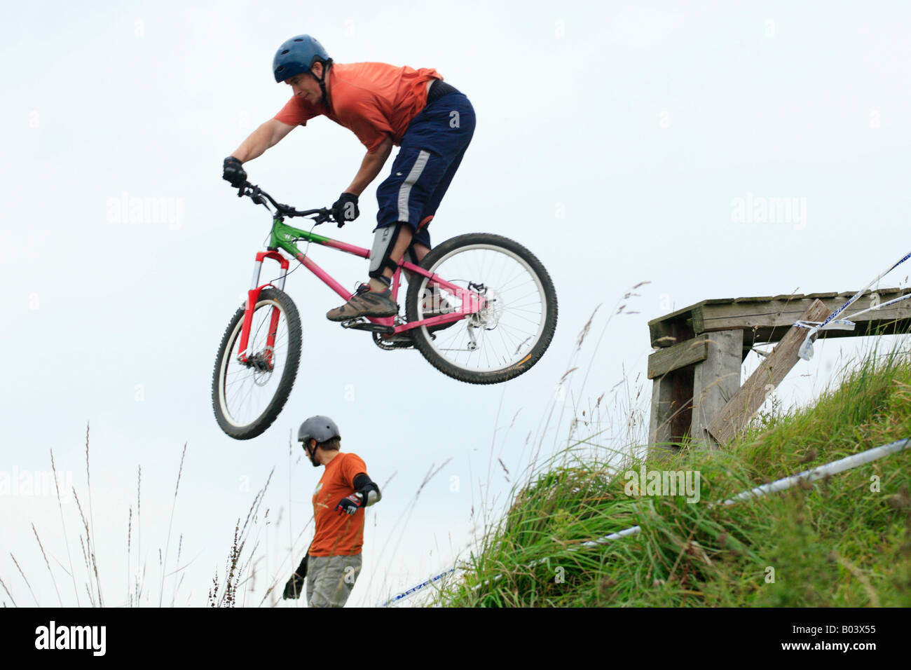 young man jumping off a ramp with his bike Stock Photo - Alamy