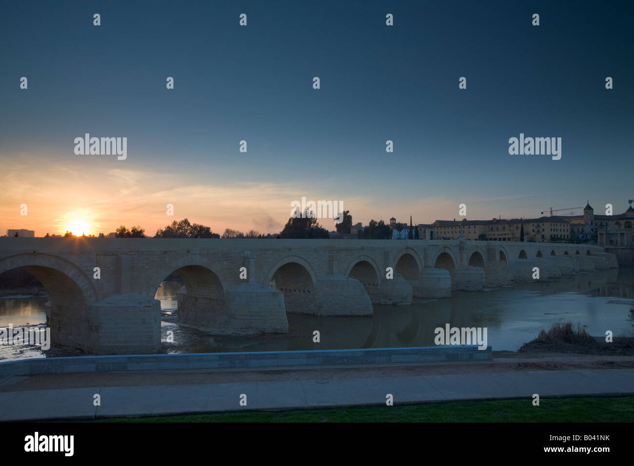Puente Romano (bridge) spanning the Rio Guadalquivir (river) at sunset ...