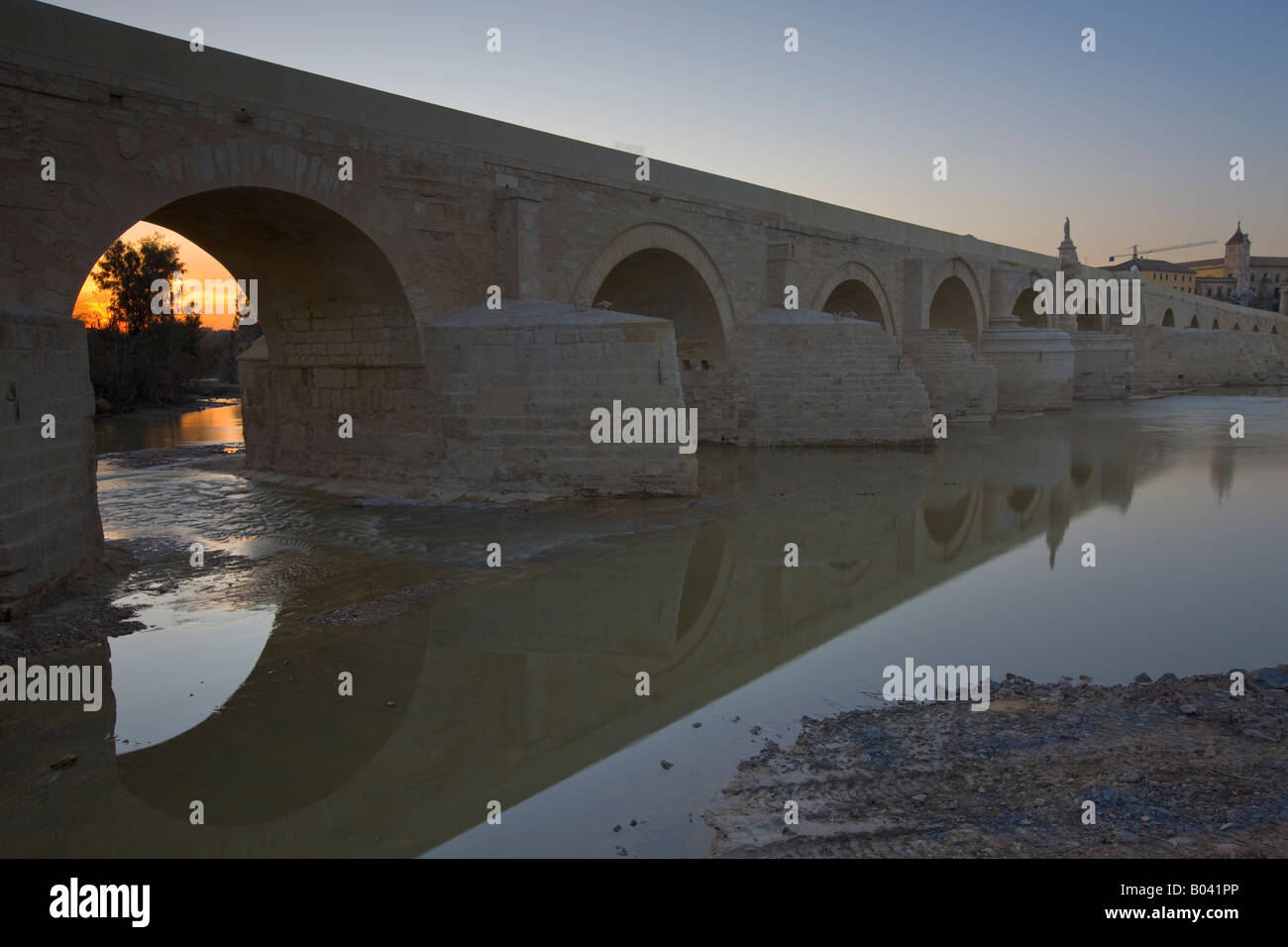 Puente Romano (bridge) spanning the Rio Guadalquivir (river) at sunset ...
