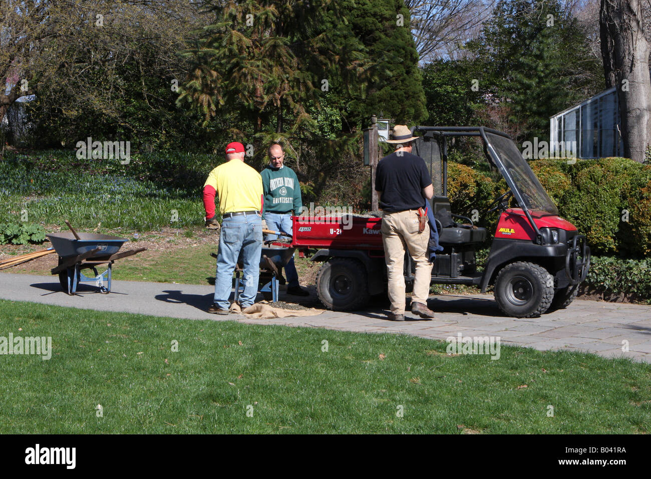 Three men getting ready to spread some mulch Stock Photo - Alamy
