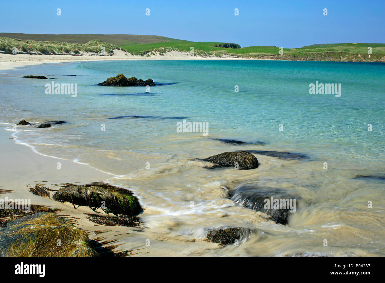 Summer beach approaching wave blue sea rocks and white sand at beach of ...