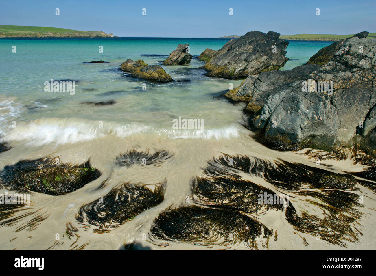 Summer beach approaching wave blue sea rocks and white sand at beach of ...