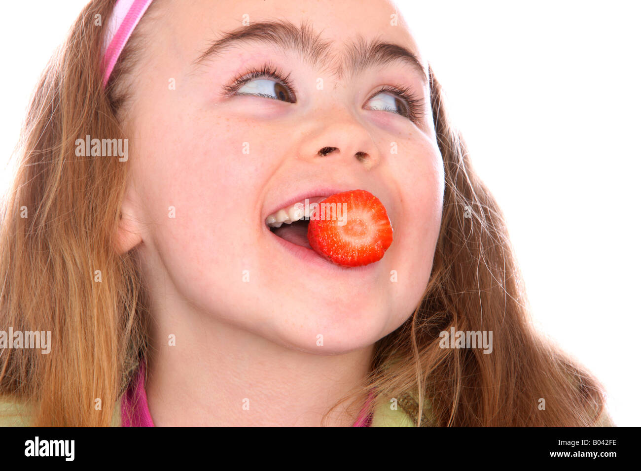 Young Girl Eating a Strawberry Model Released Stock Photo - Alamy