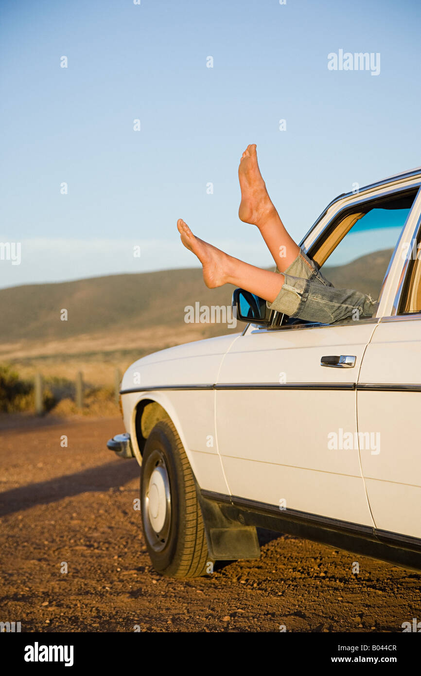 Young womans feet sticking out of a car window Stock Photo - Alamy