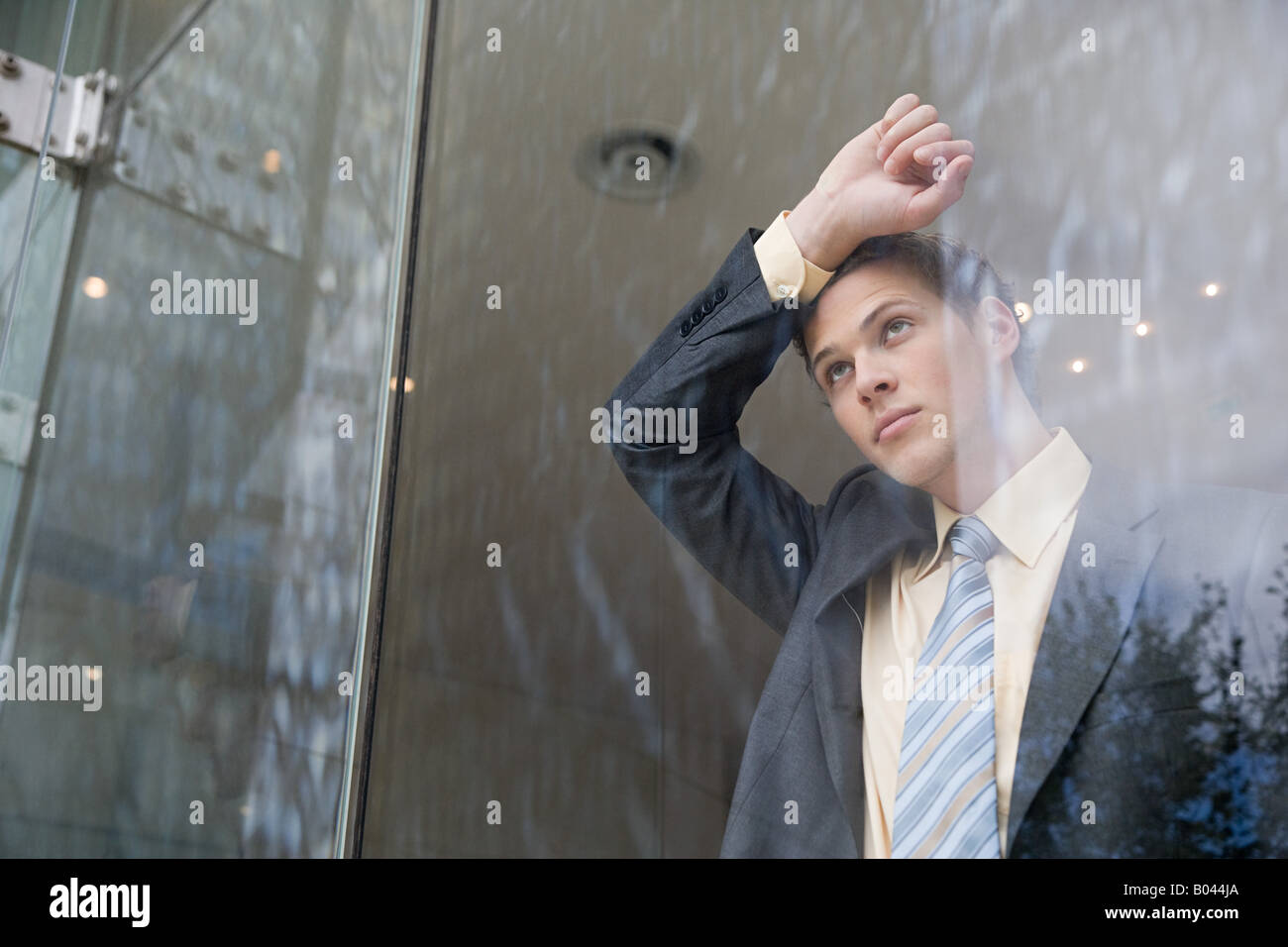 Businessman leaning on window Stock Photo - Alamy