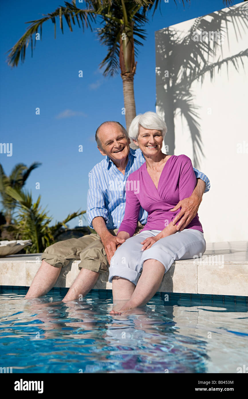 A couple sat next to a swimming pool Stock Photo - Alamy