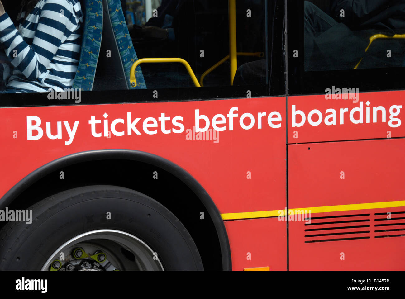 Sign on side of red London bus asking passengers to buy tickets before ...