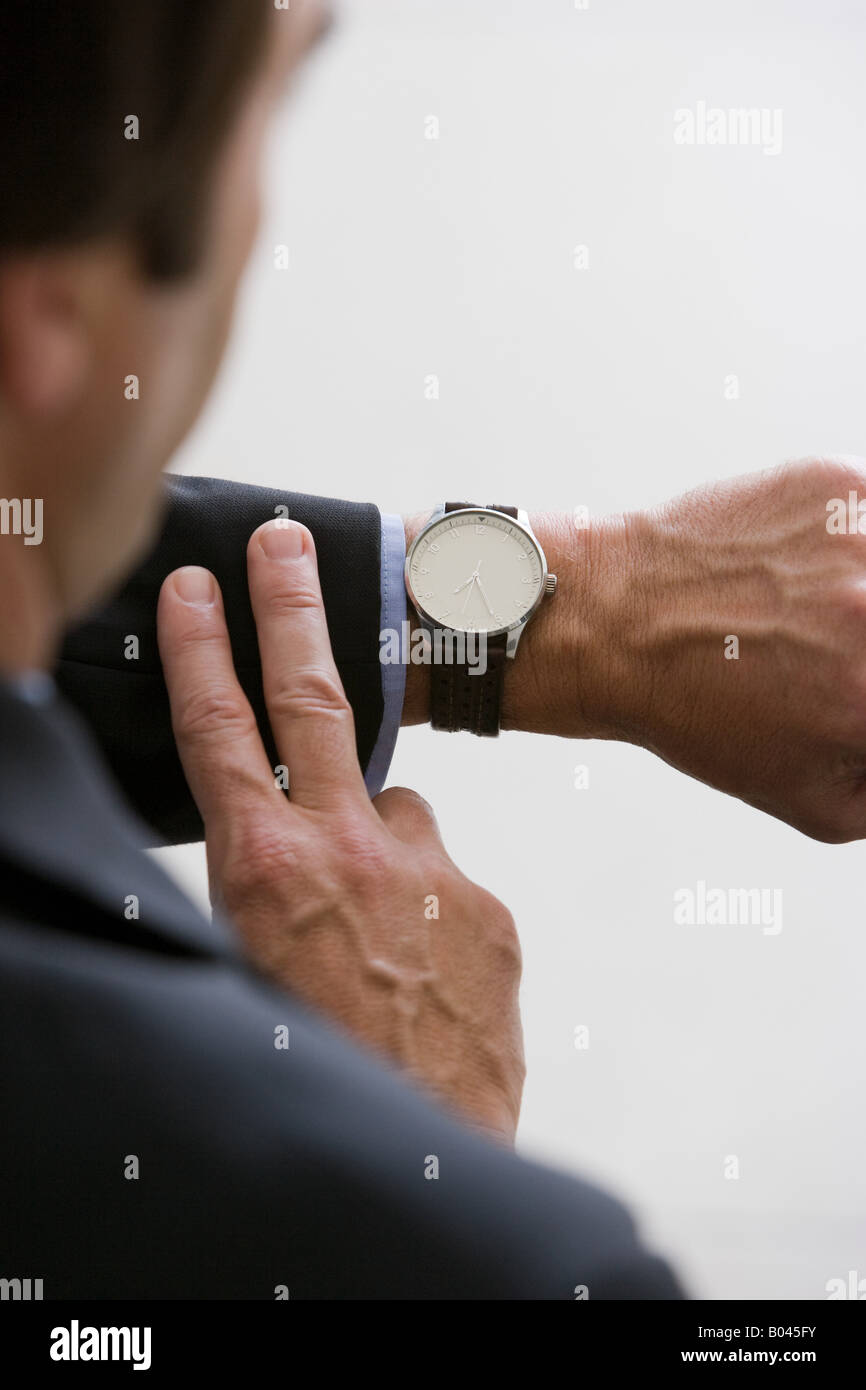 A businessman looking at his watch Stock Photo - Alamy
