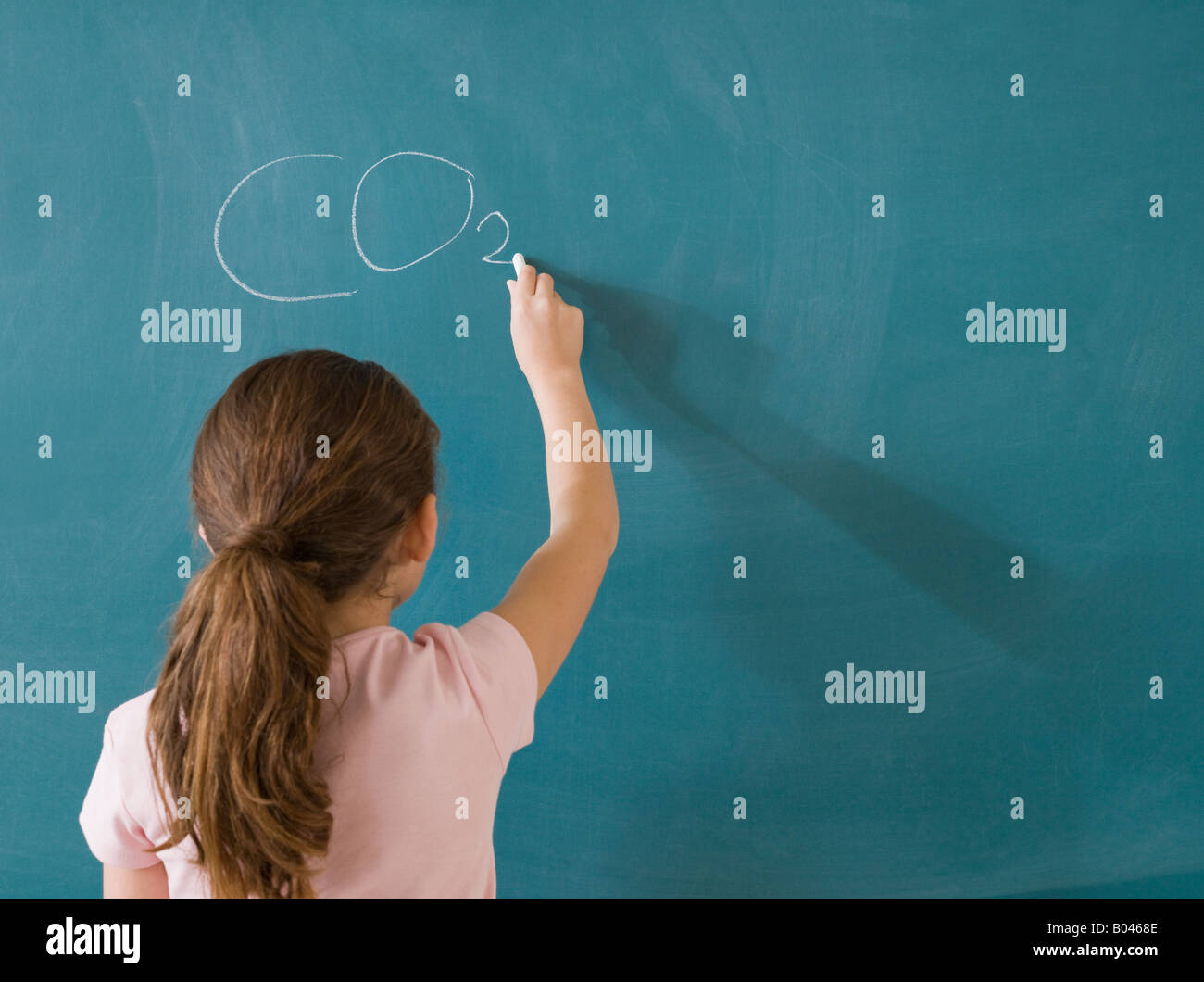 Girl writing on a blackboard Stock Photo - Alamy