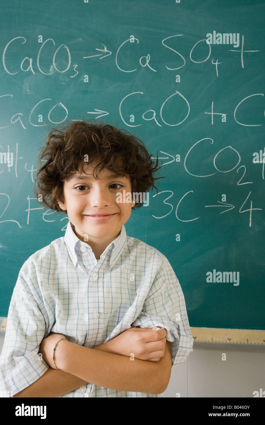 Boy standing by blackboard Stock Photo - Alamy