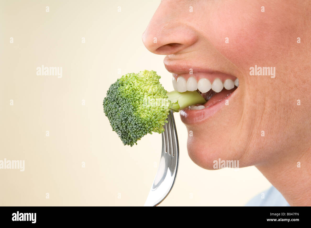 A woman eating broccoli Stock Photo - Alamy