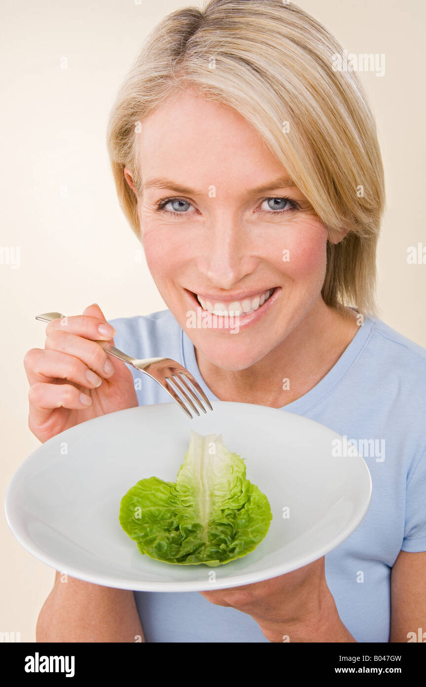 A woman holding a plate with a lettuce Stock Photo - Alamy