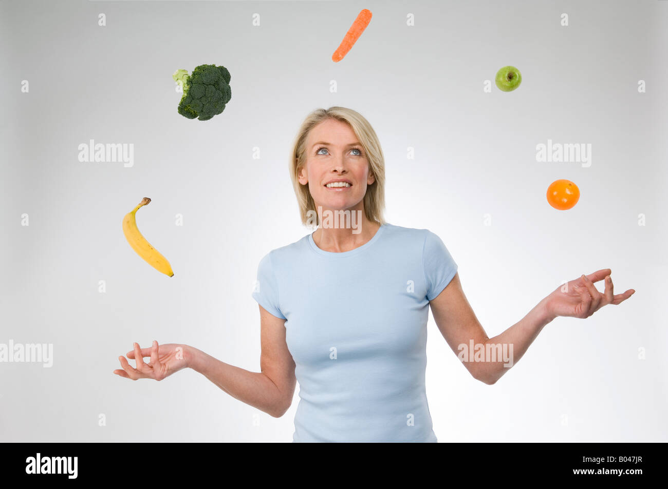 A woman juggling fruit and vegetables Stock Photo - Alamy