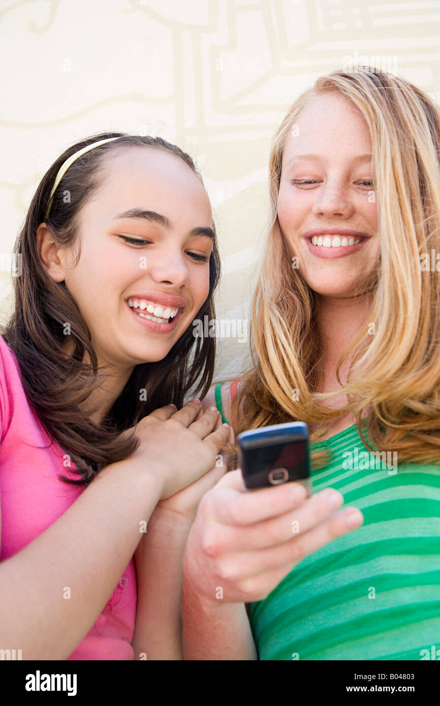 Teenage girls using a cell phone Stock Photo - Alamy