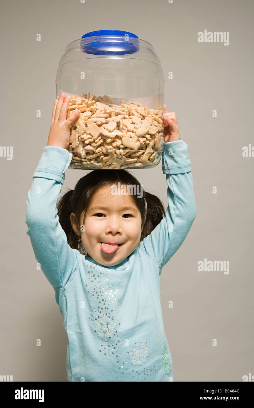 A girl holding a jar of biscuits Stock Photo - Alamy