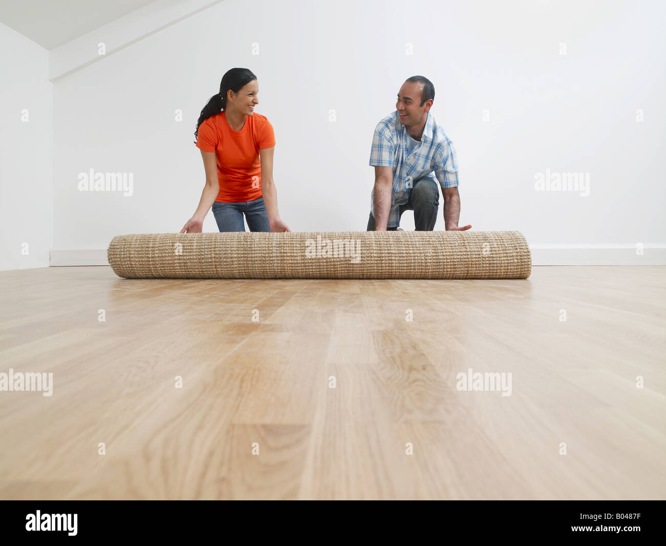 A couple rolling out a rug Stock Photo - Alamy