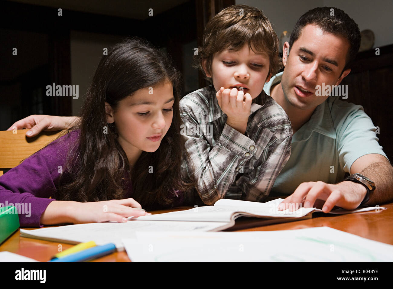 A father supervising his children with their homework Stock Photo - Alamy