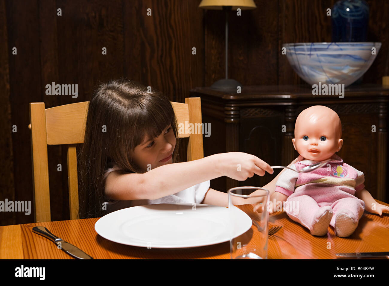 Girl feeding a doll Stock Photo - Alamy