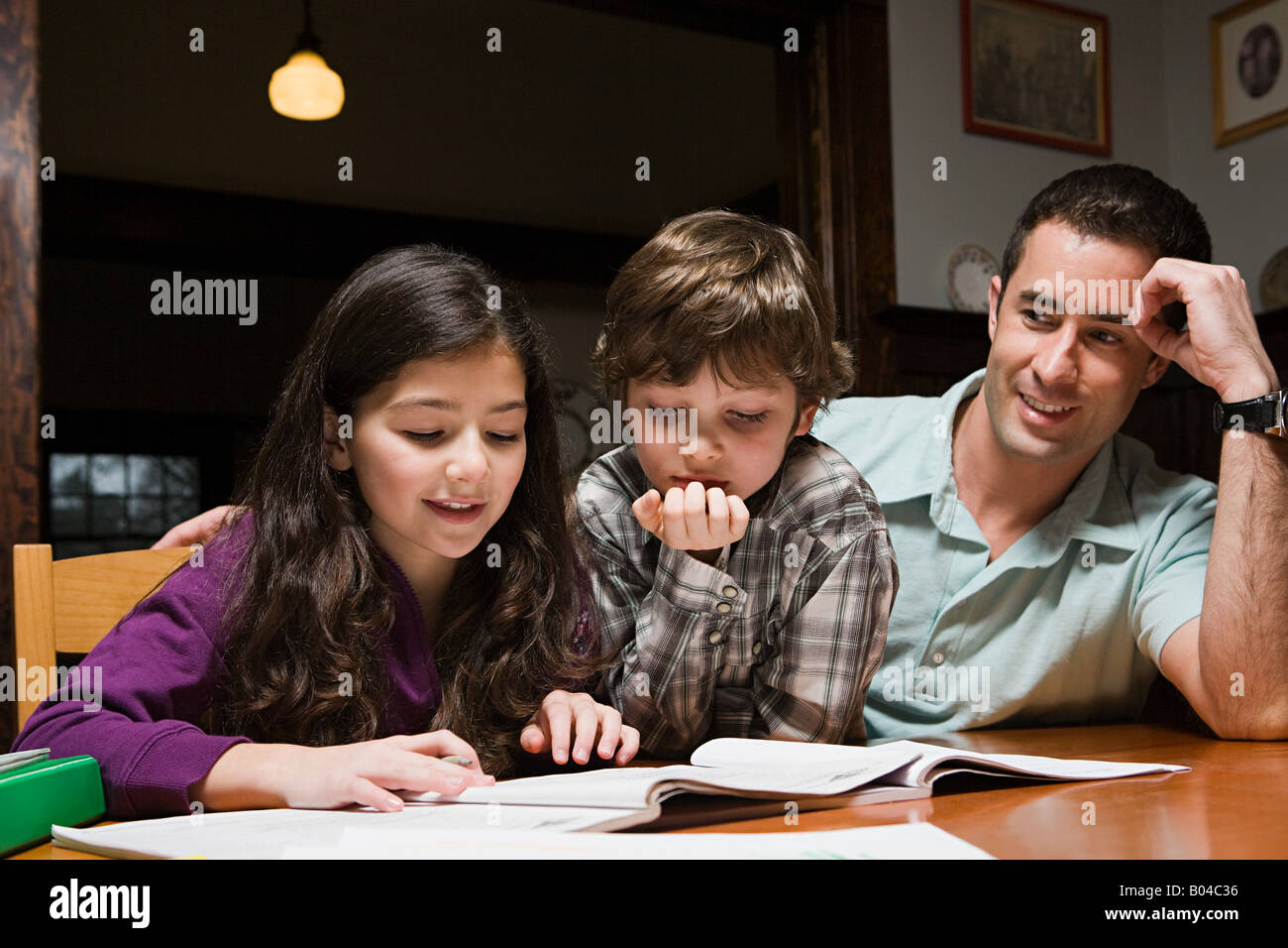 A father supervising his children with their homework Stock Photo - Alamy