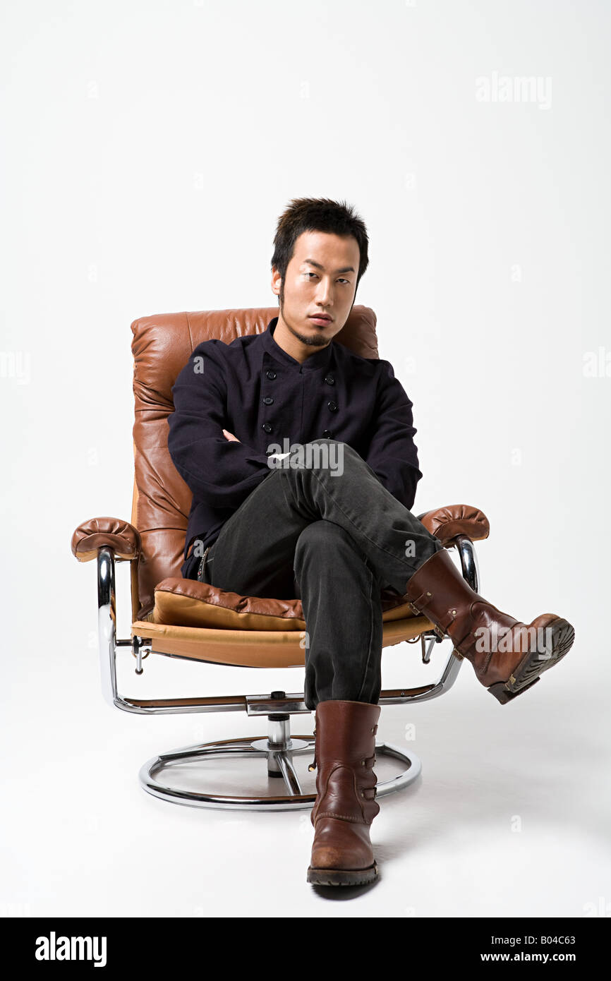 Japanese man sitting on a leather armchair Stock Photo - Alamy
