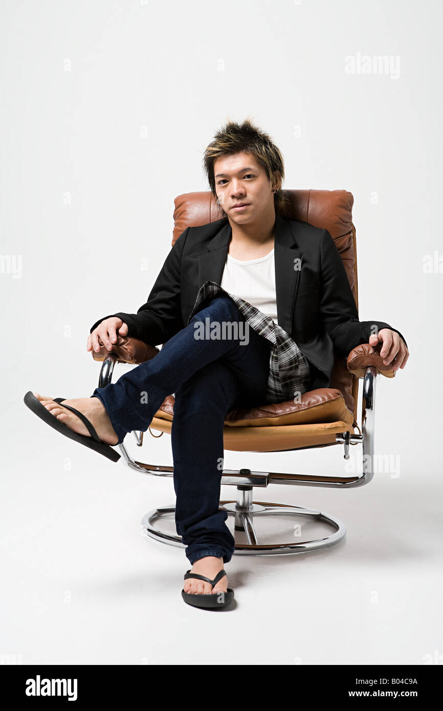 Japanese man sitting on a leather armchair Stock Photo - Alamy