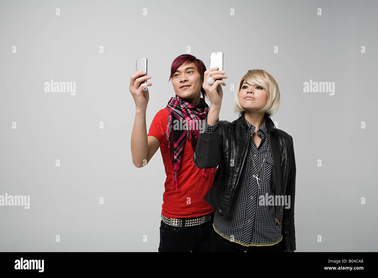Couple using camera telephones Stock Photo - Alamy