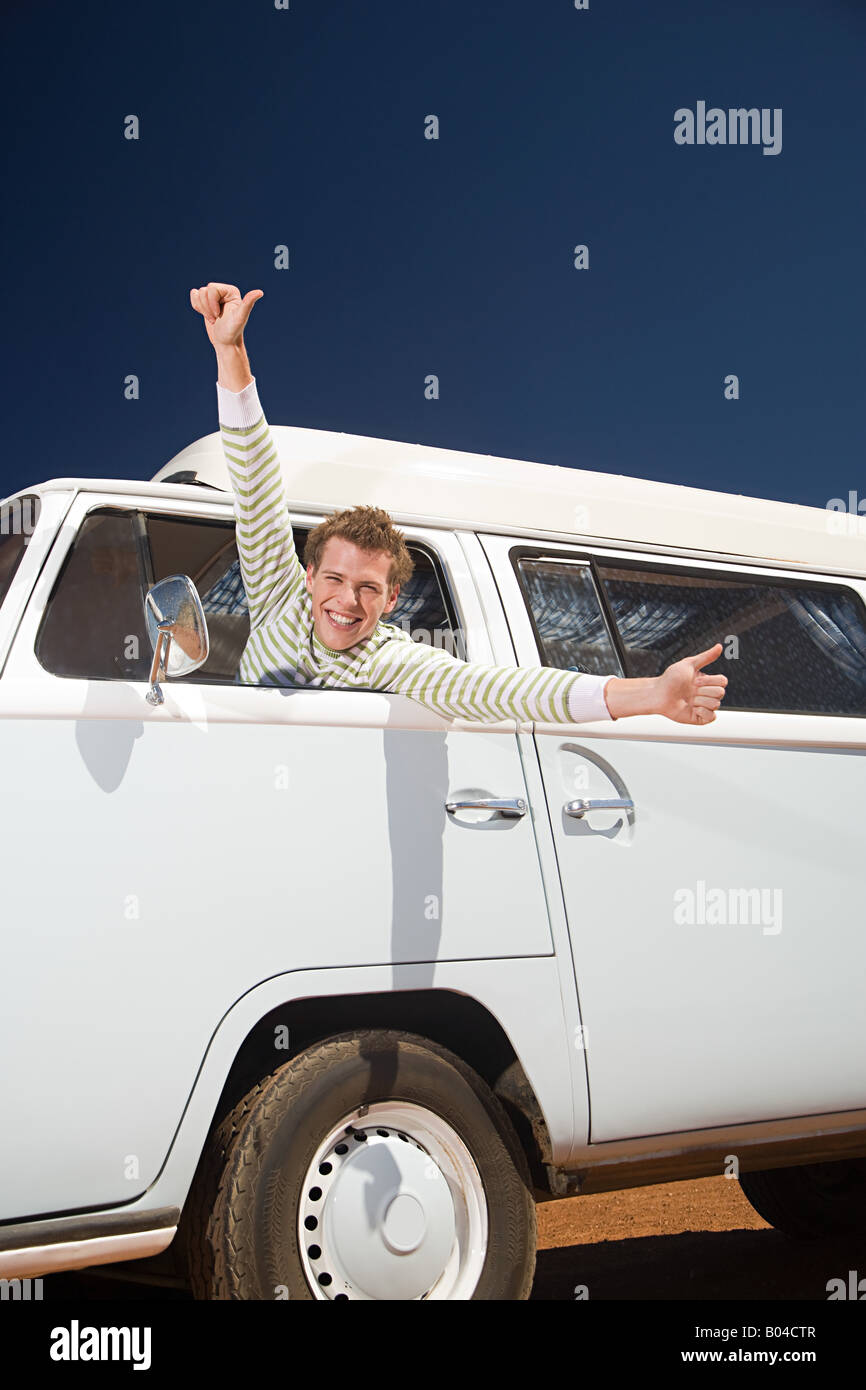 A young man driving a camper van Stock Photo - Alamy