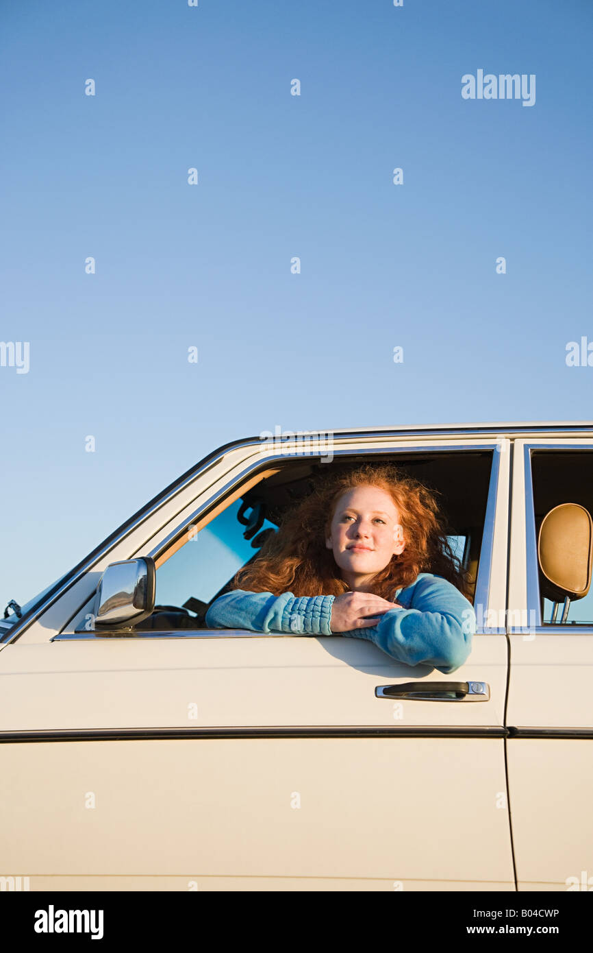 A young woman leaning out of a car window Stock Photo - Alamy