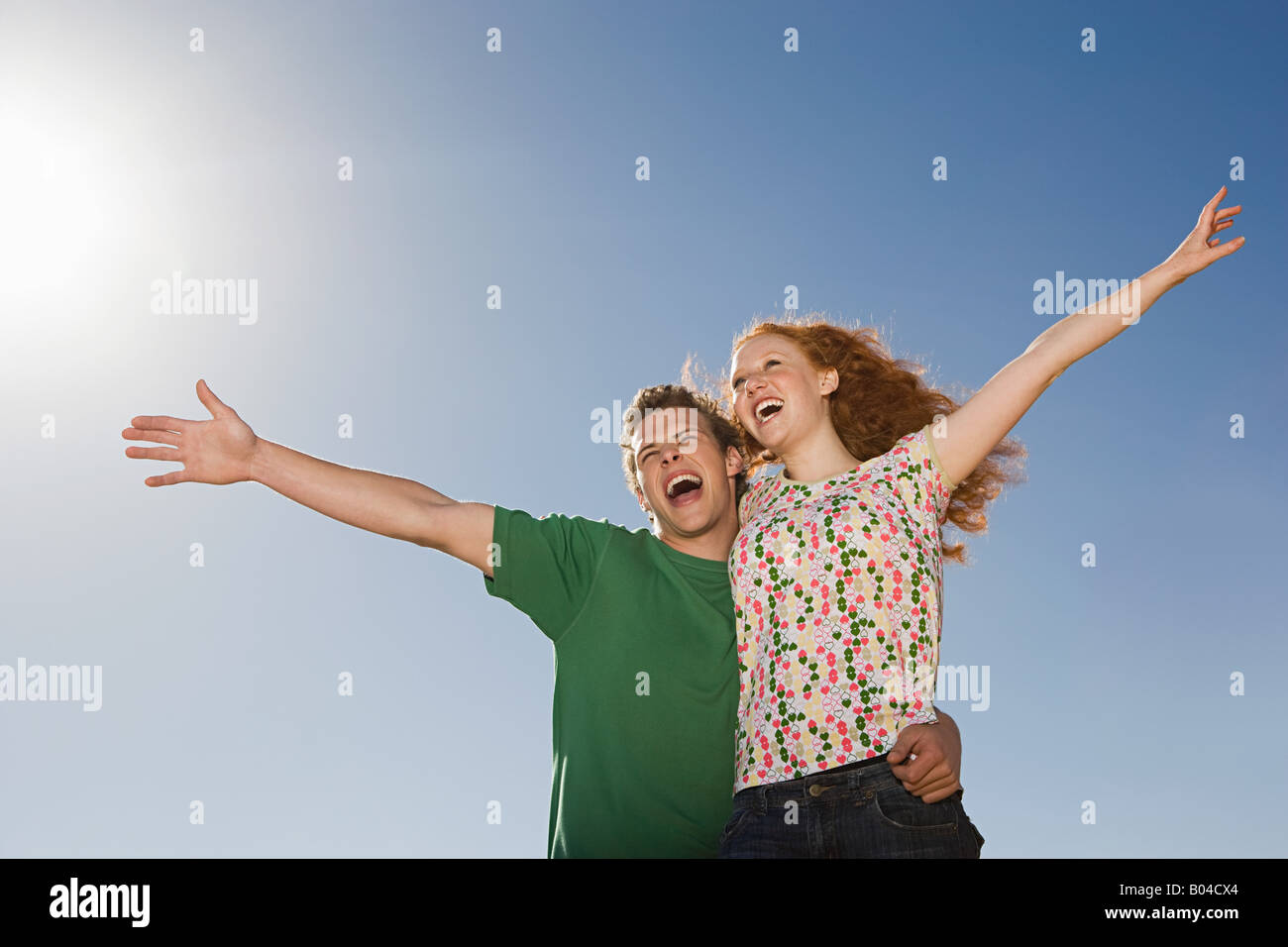 A couple with their arms raised Stock Photo - Alamy
