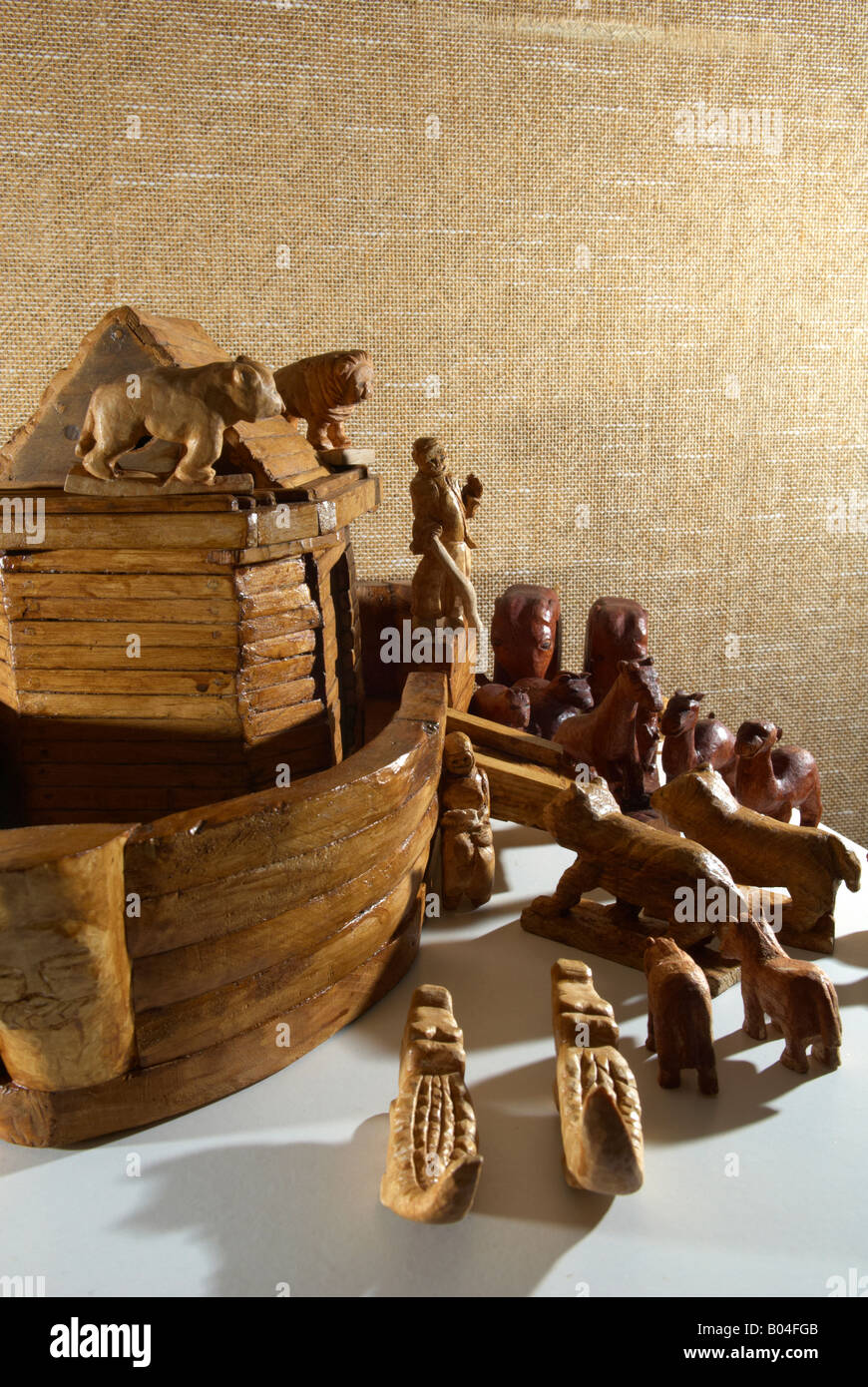 Wood carving of Noah holding a stick and his Ark back lit by a flash ...