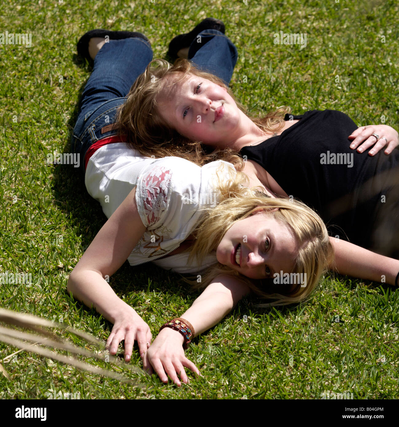 Two young women frolicking on the grass, Costa del Sol, Spain Stock ...