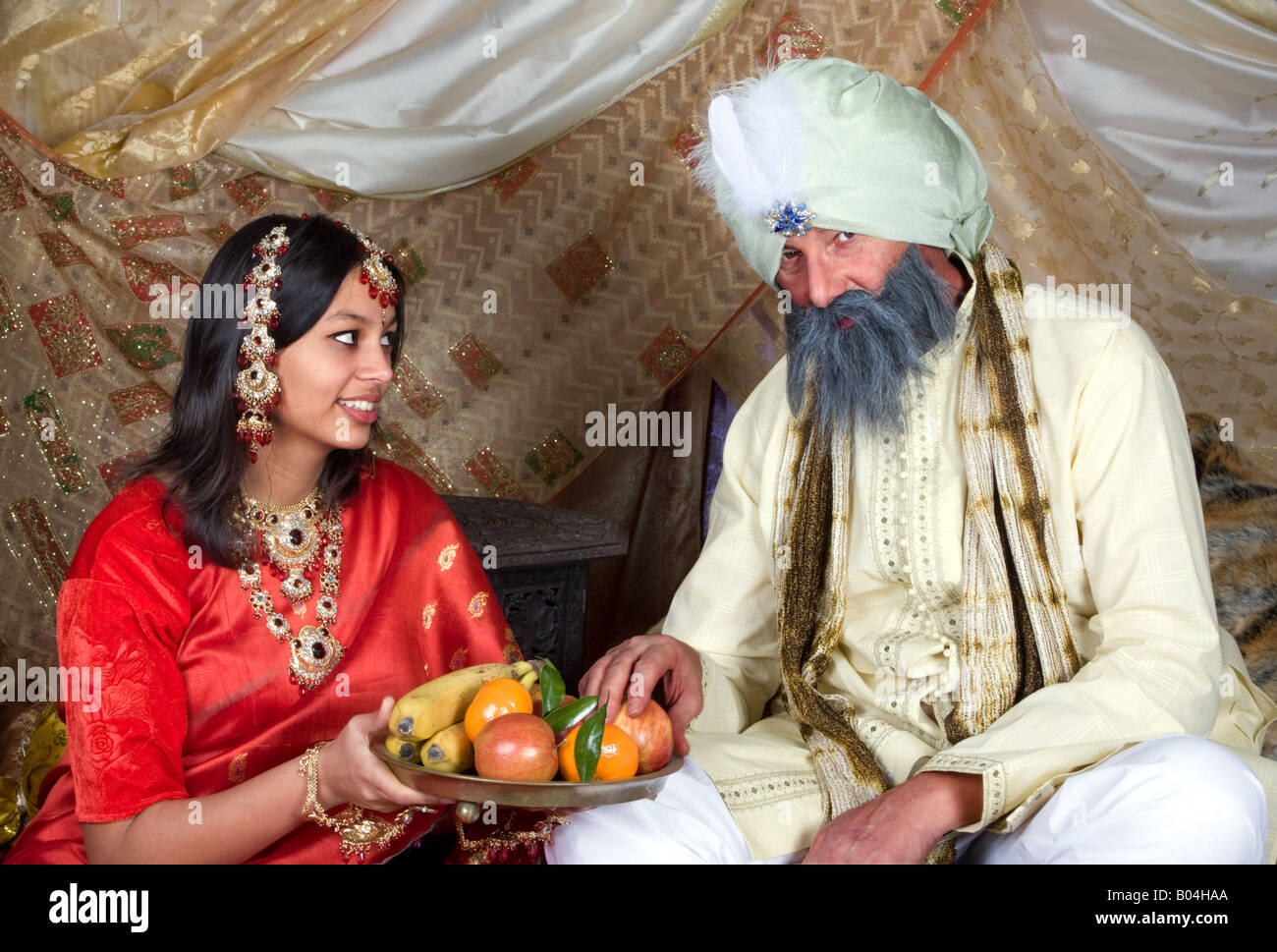 Exotic beauty offering fruit to Arabian sultan Stock Photo - Alamy