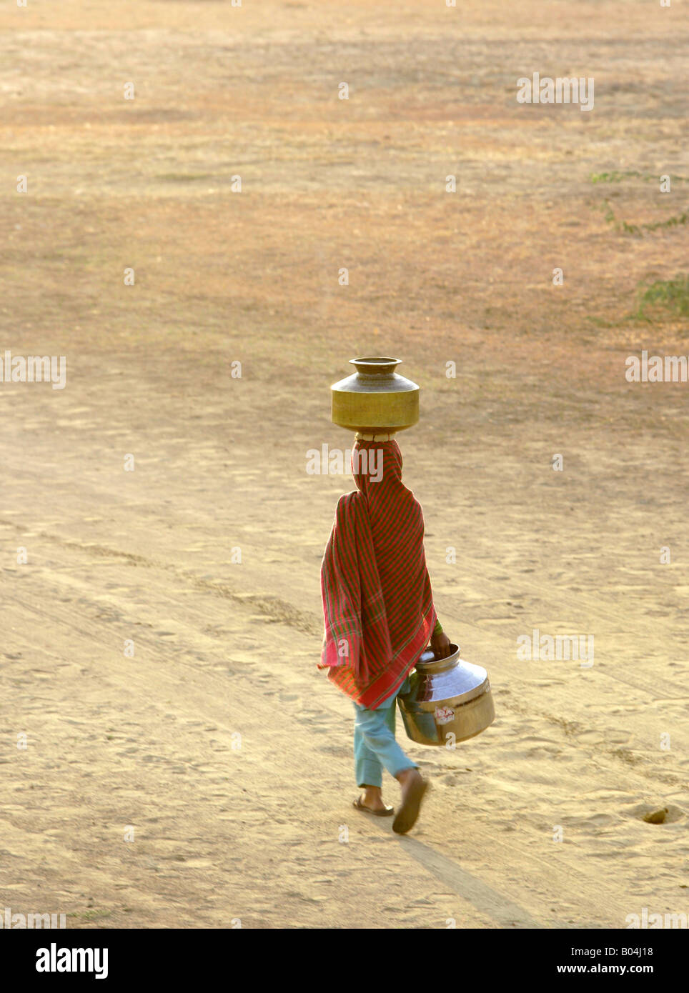 Young girl fetching water and balancing a container on her head, Near ...