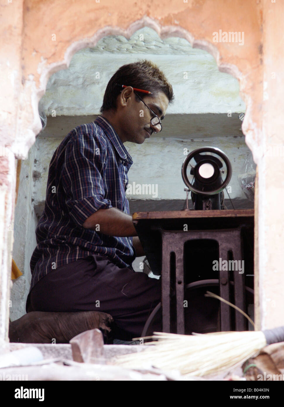 Man using an old sewing machine framed by archway, Jodhpur, Rajasthan ...