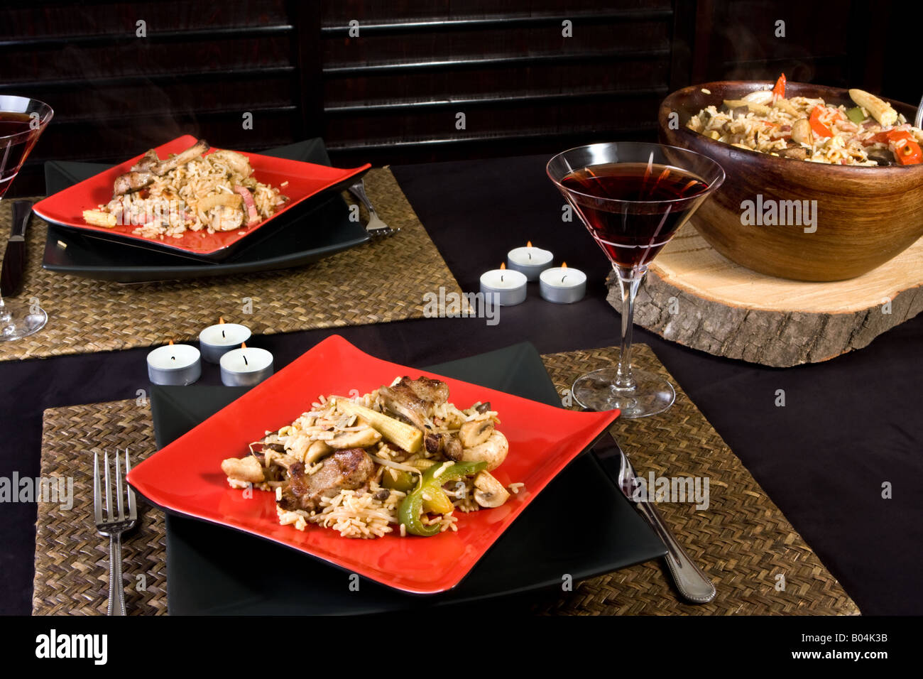 Delicious wooden bowl with pilaf rice on a black and red table setting ...