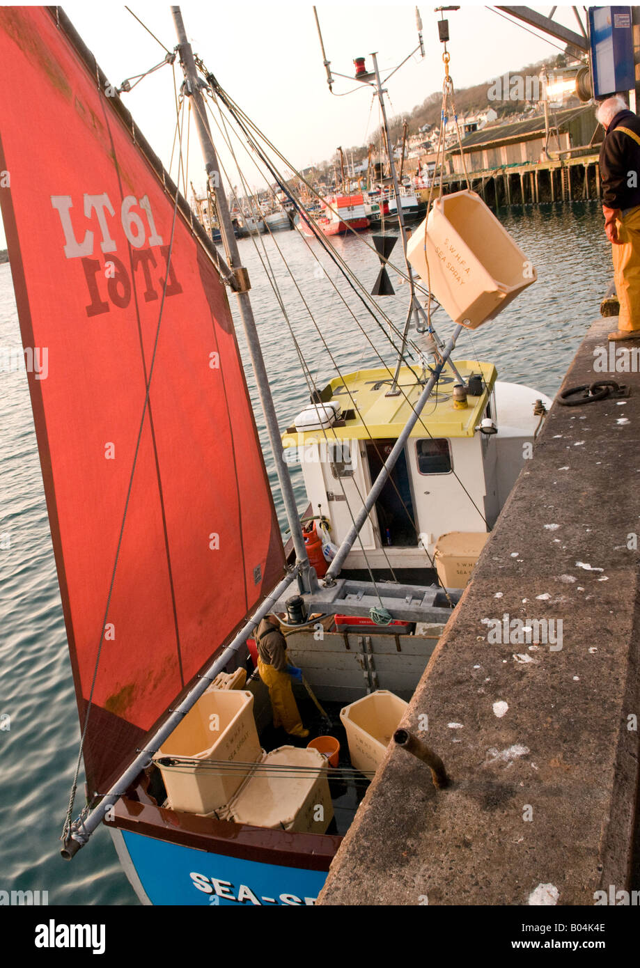 Ice boxes being loaded onto fishing boat at Newlyn Harbour, Cornwall ...